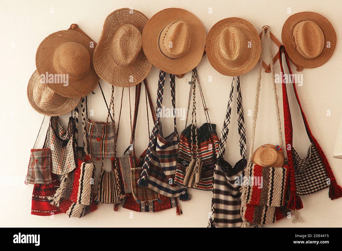 Traditional Romanian handmade woolen bags and straw hats on a clothing ...