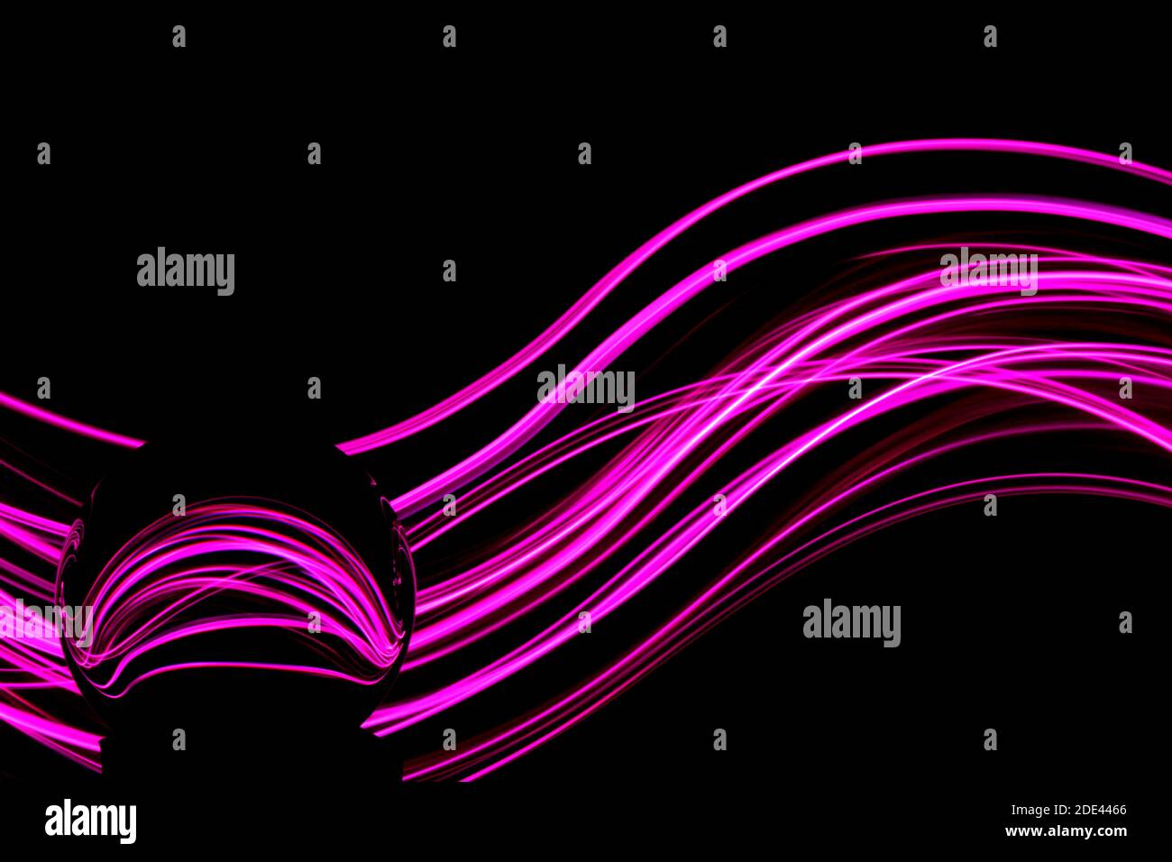 Long exposure photograph of neon pink colour in an abstract swirl ...