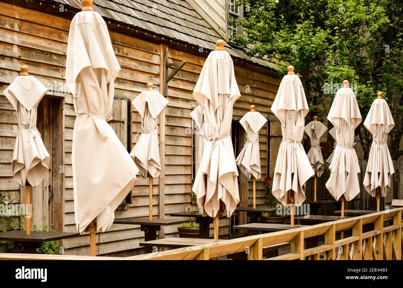 A restaurant's empty wooden patio dining area with tightly closed and ...