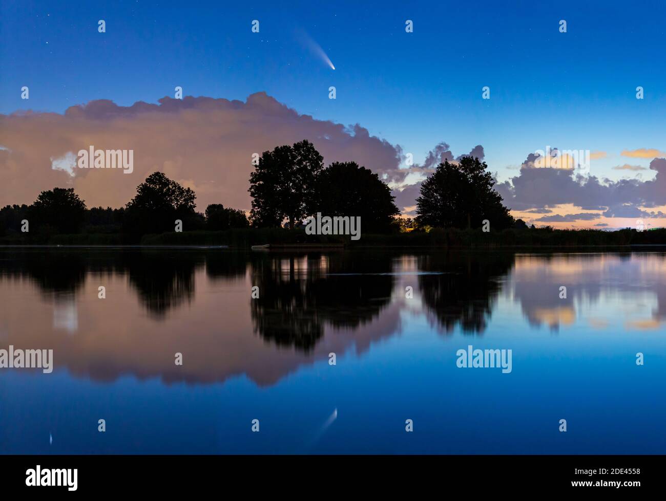 Meteor, shooting star or falling star seen in a night sky with clouds ...