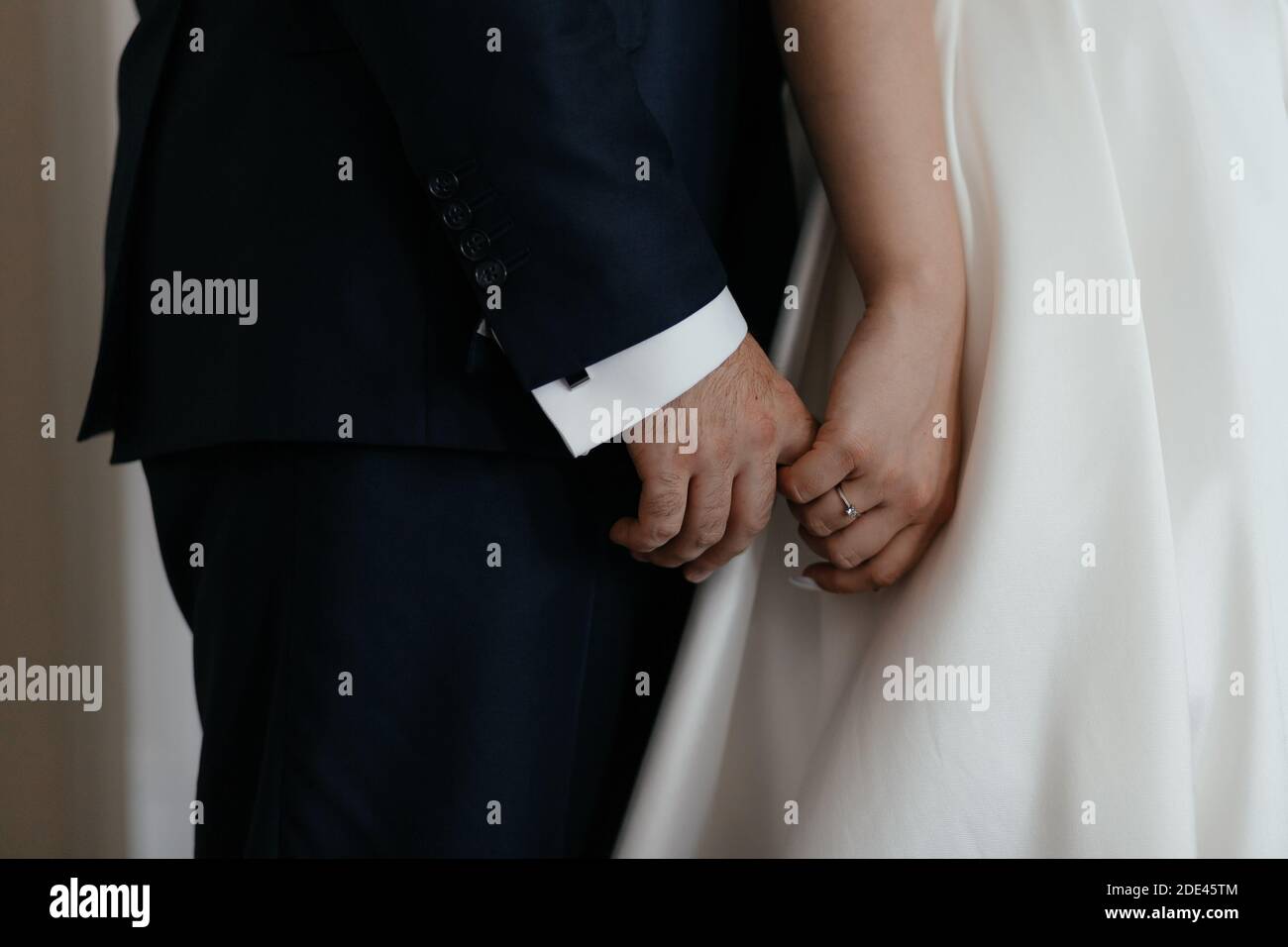 Bride holding his fiance hand. Closeup couple hands. Couple in love ...