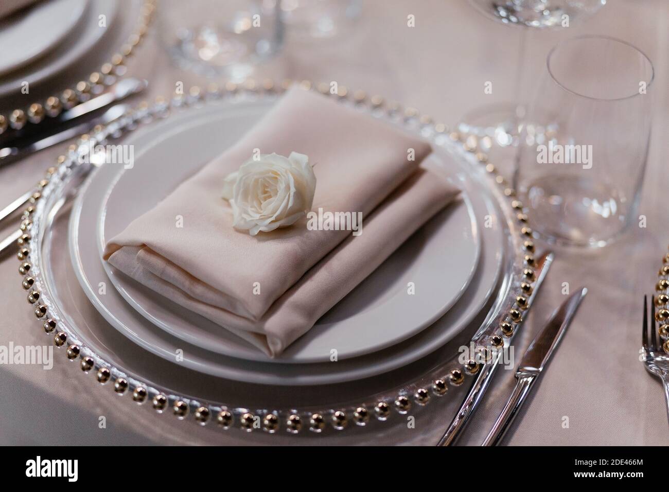 Set of plates with beige napkin above. Luxury table set in the ...