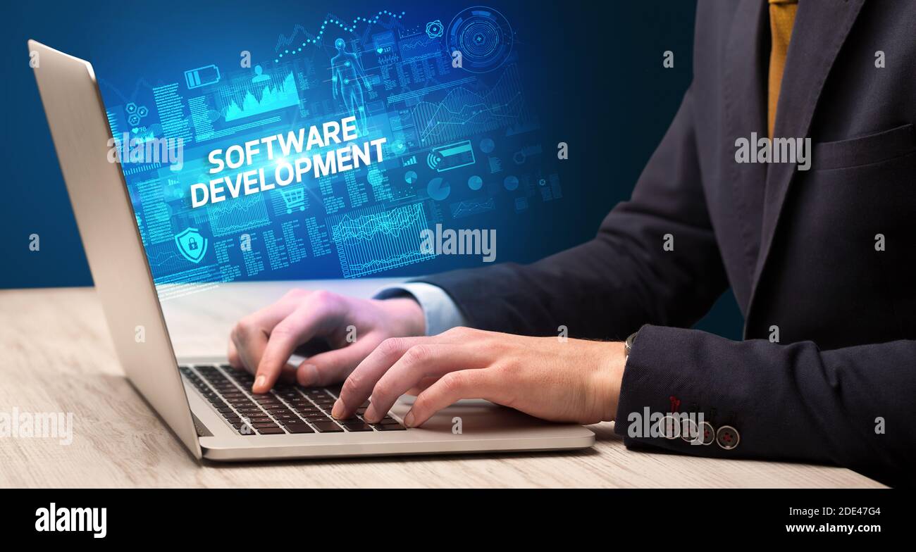 Businessman working on laptop with SOFTWARE DEVELOPMENT inscription ...