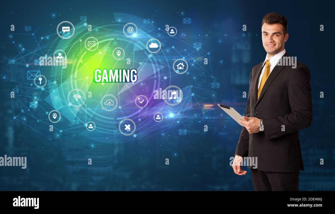 Businessman thinking in front of technology related icons and GAMING ...