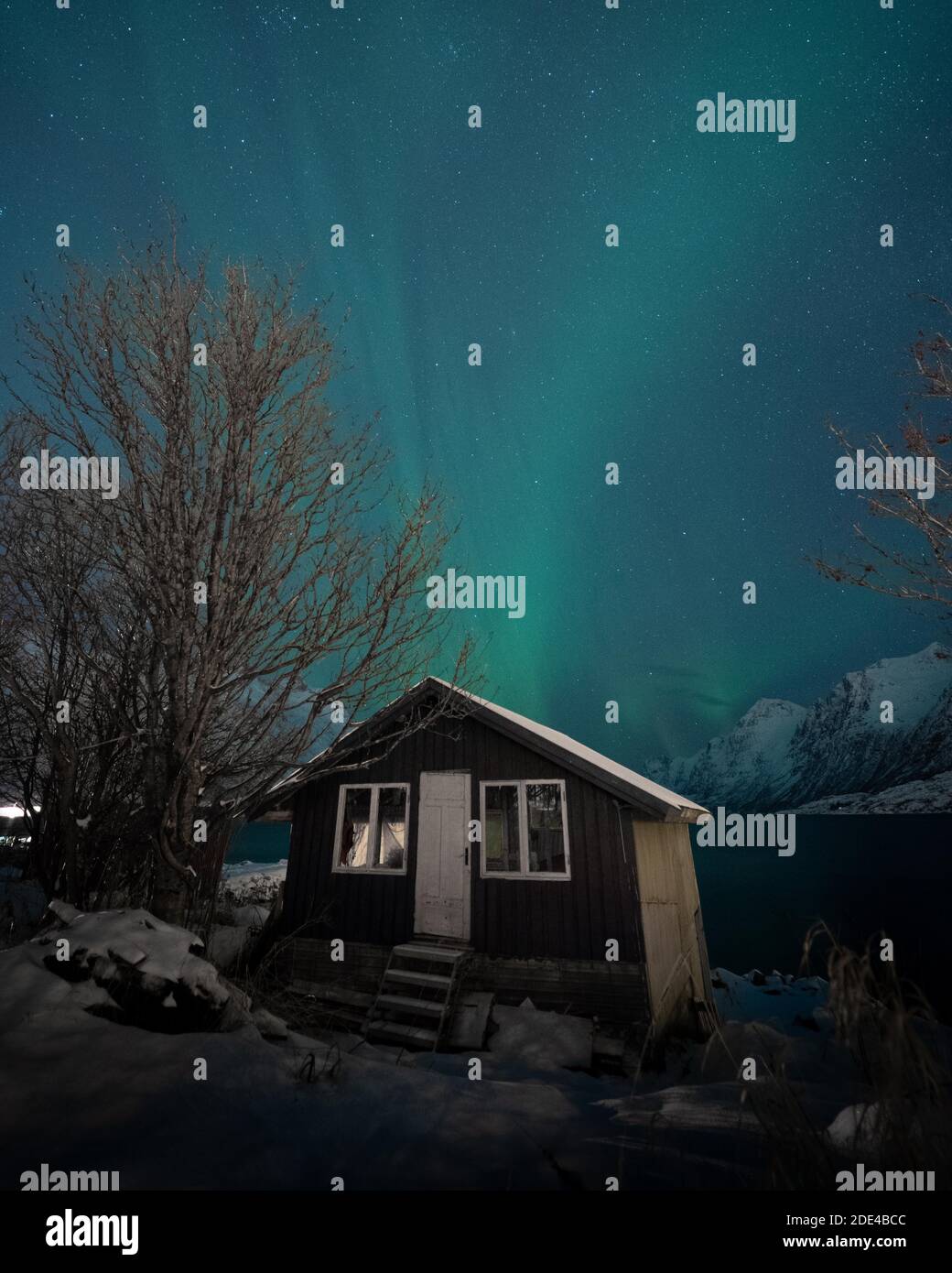 Northern lights over a Norwegian fjord with Norwegian hut, Tromso ...