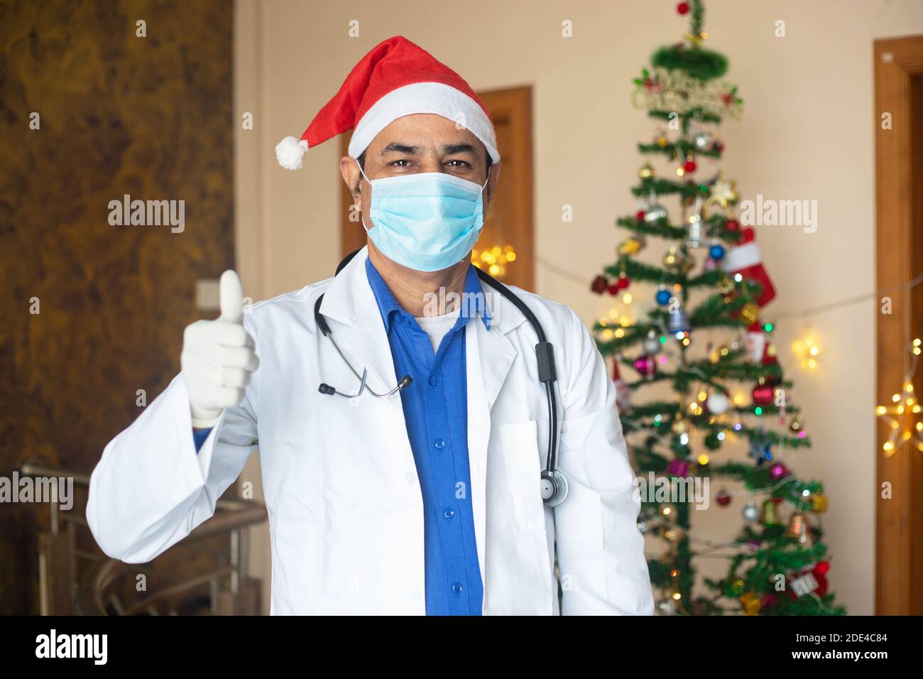 Doctor wearing mask and christmas santa hat doing thumb up, healthcare ...