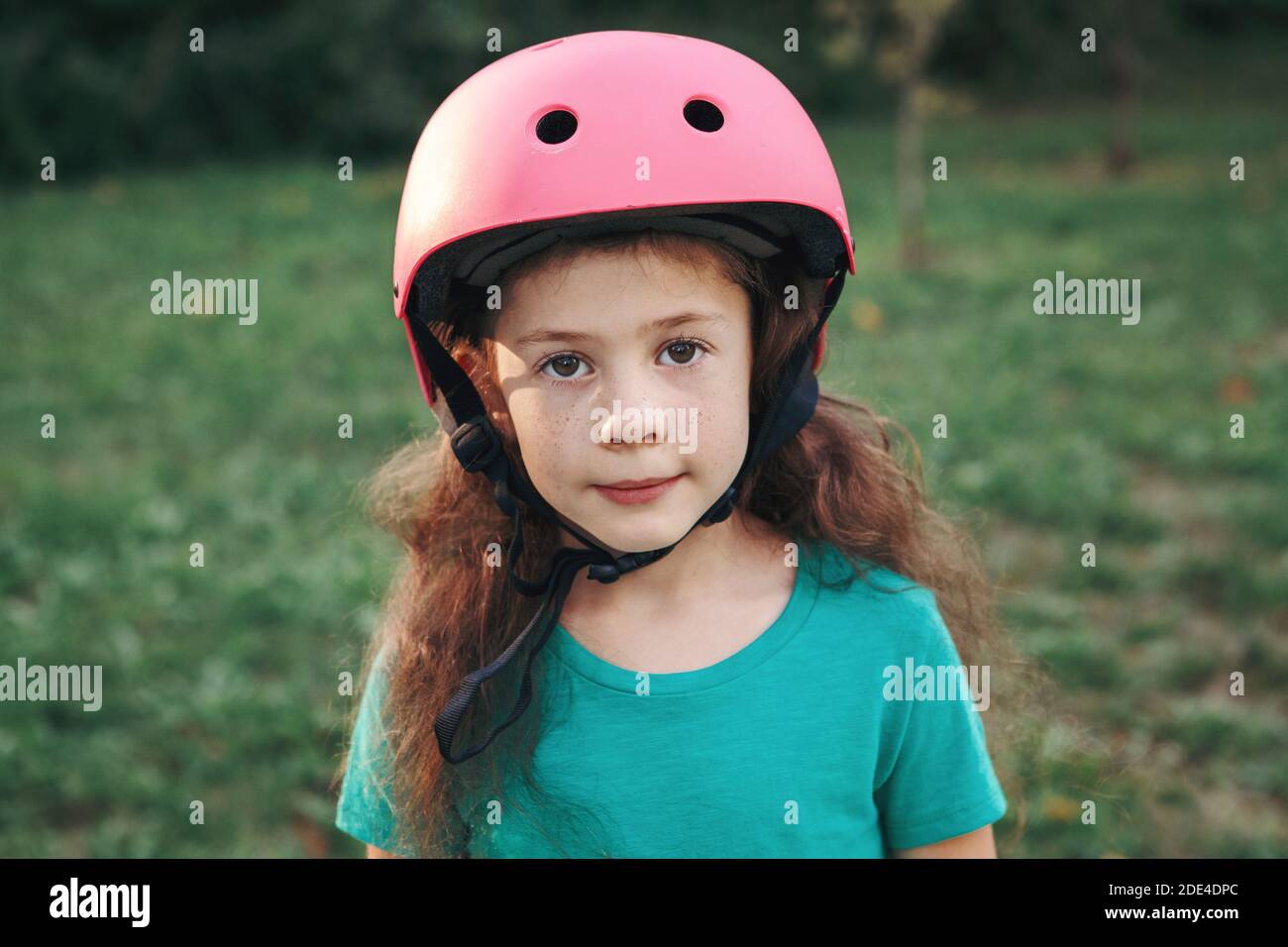 Closeup portrait of adorable pretty cute Caucasian girl in pink helmet ...
