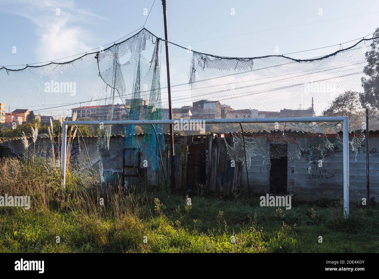 goal with broken net and abandoned wooden changing rooms with tall ...