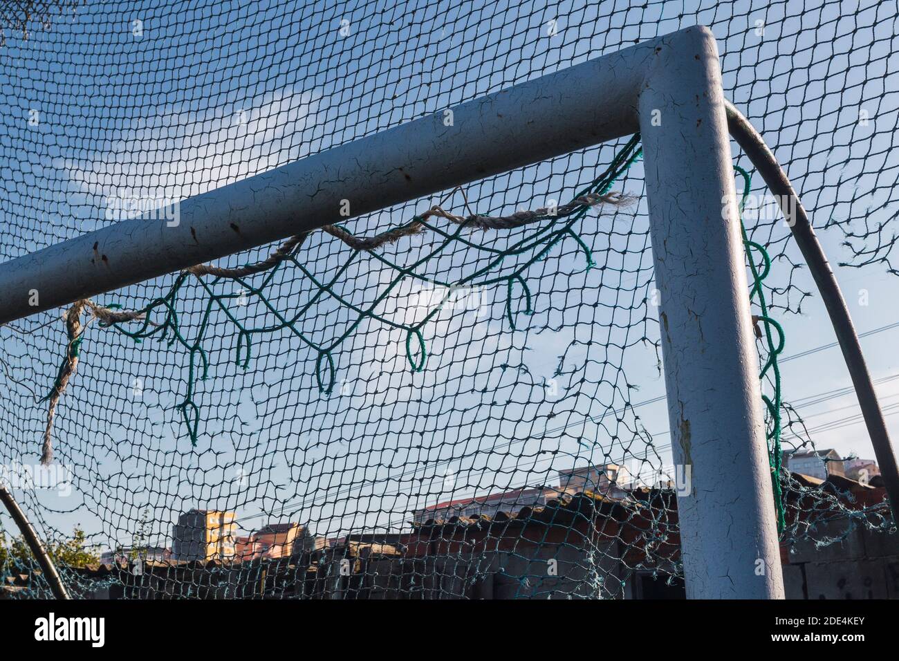 goal with broken net and abandoned wooden changing rooms with tall ...