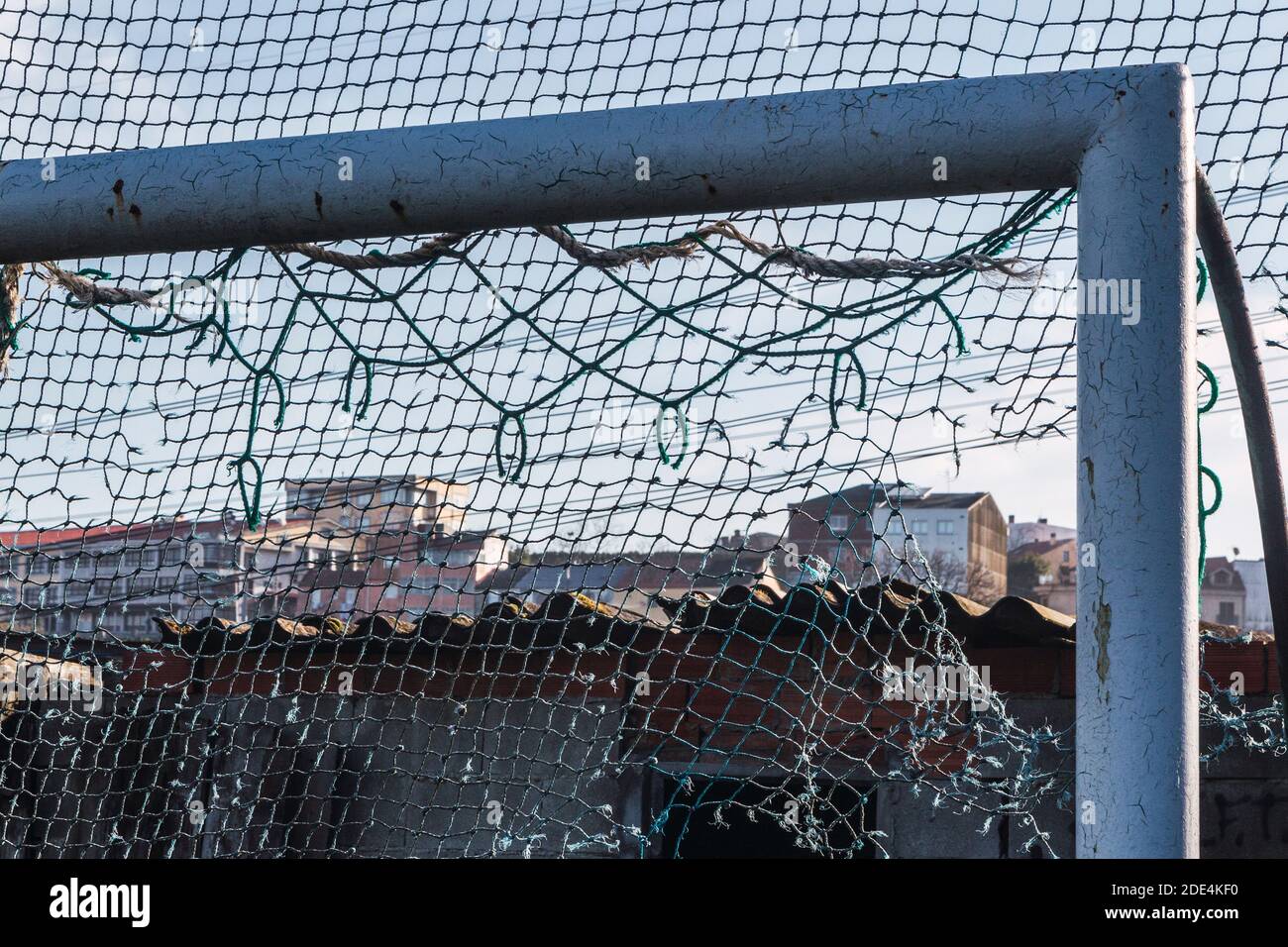 goal with broken net and abandoned wooden changing rooms with tall ...