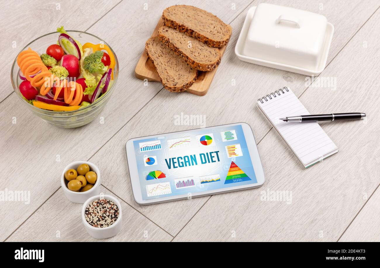 Organic food and tablet pc showing VEGAN DIET inscription, healthy ...