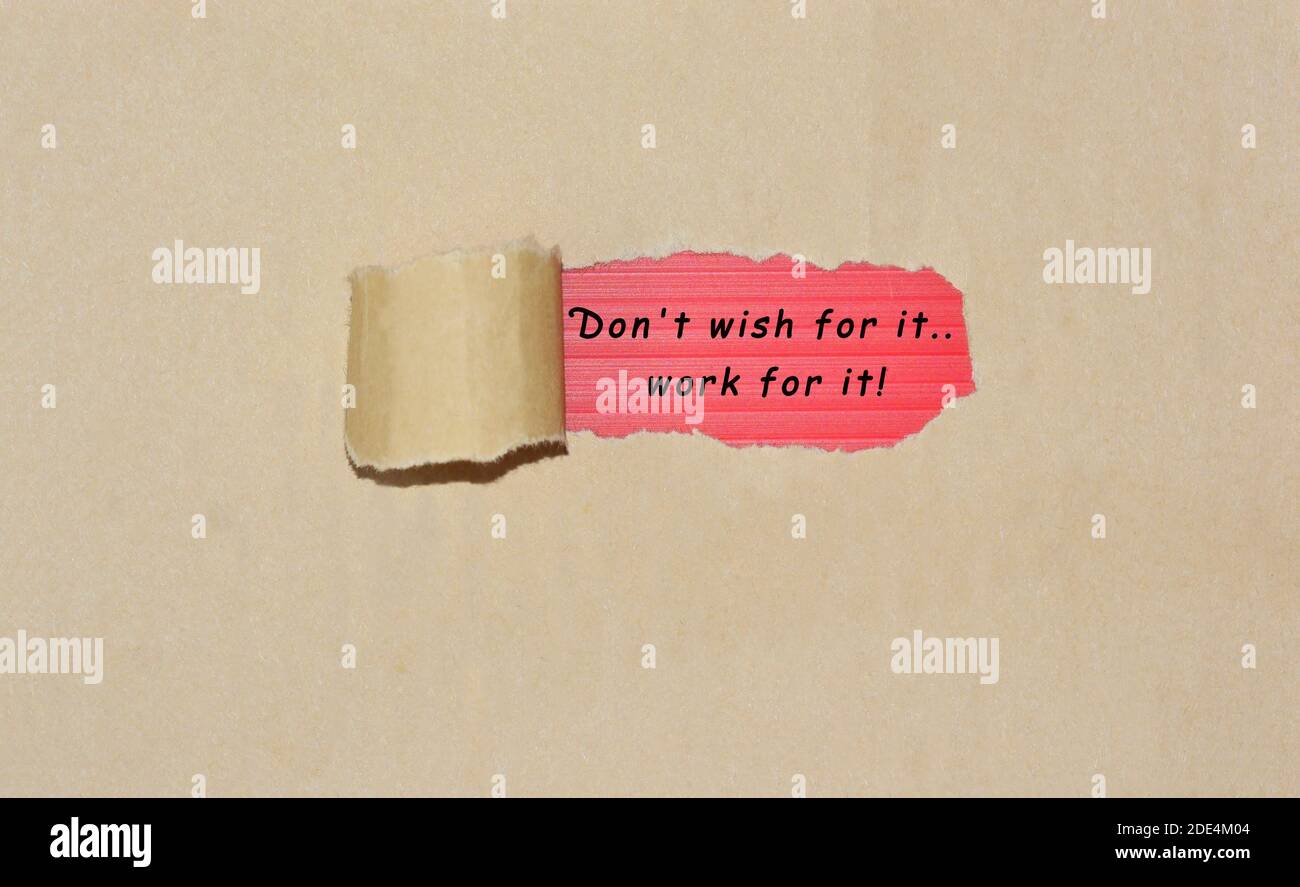 Motivational quote written on brown torn paper with red surface ...