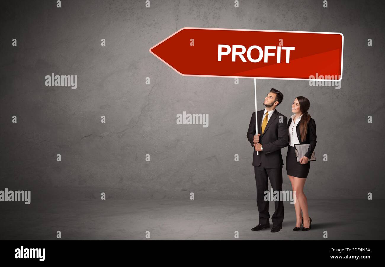 Young business person in casual holding road sign with PROFIT ...