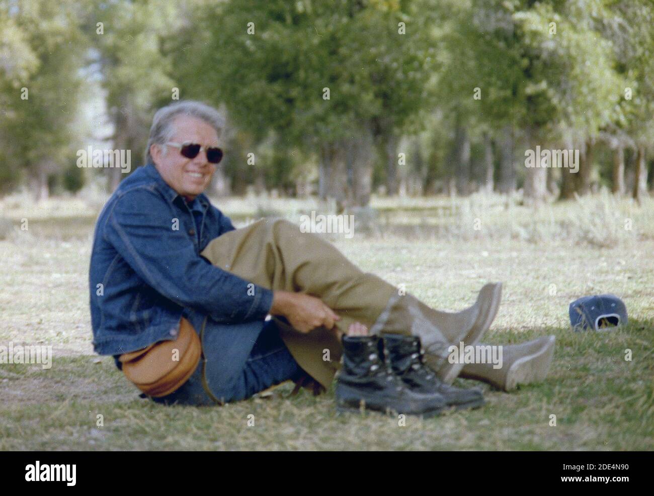 Jimmy Carter putting on his wading boot for fishing ca. 29 August 1978 ...