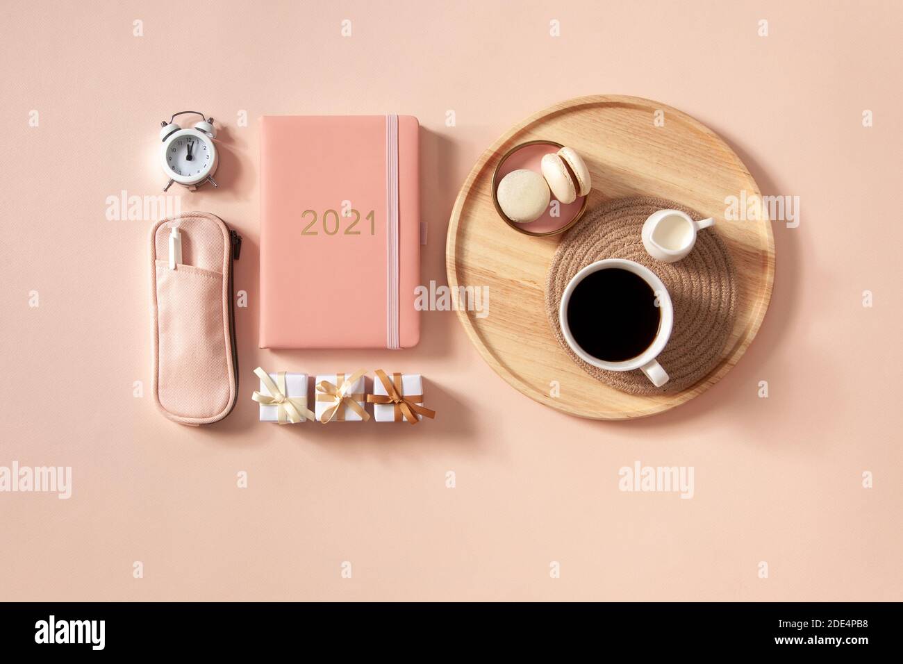 Top view of coral colored diary 2021, pen case, gift boxes, o'clock and ...