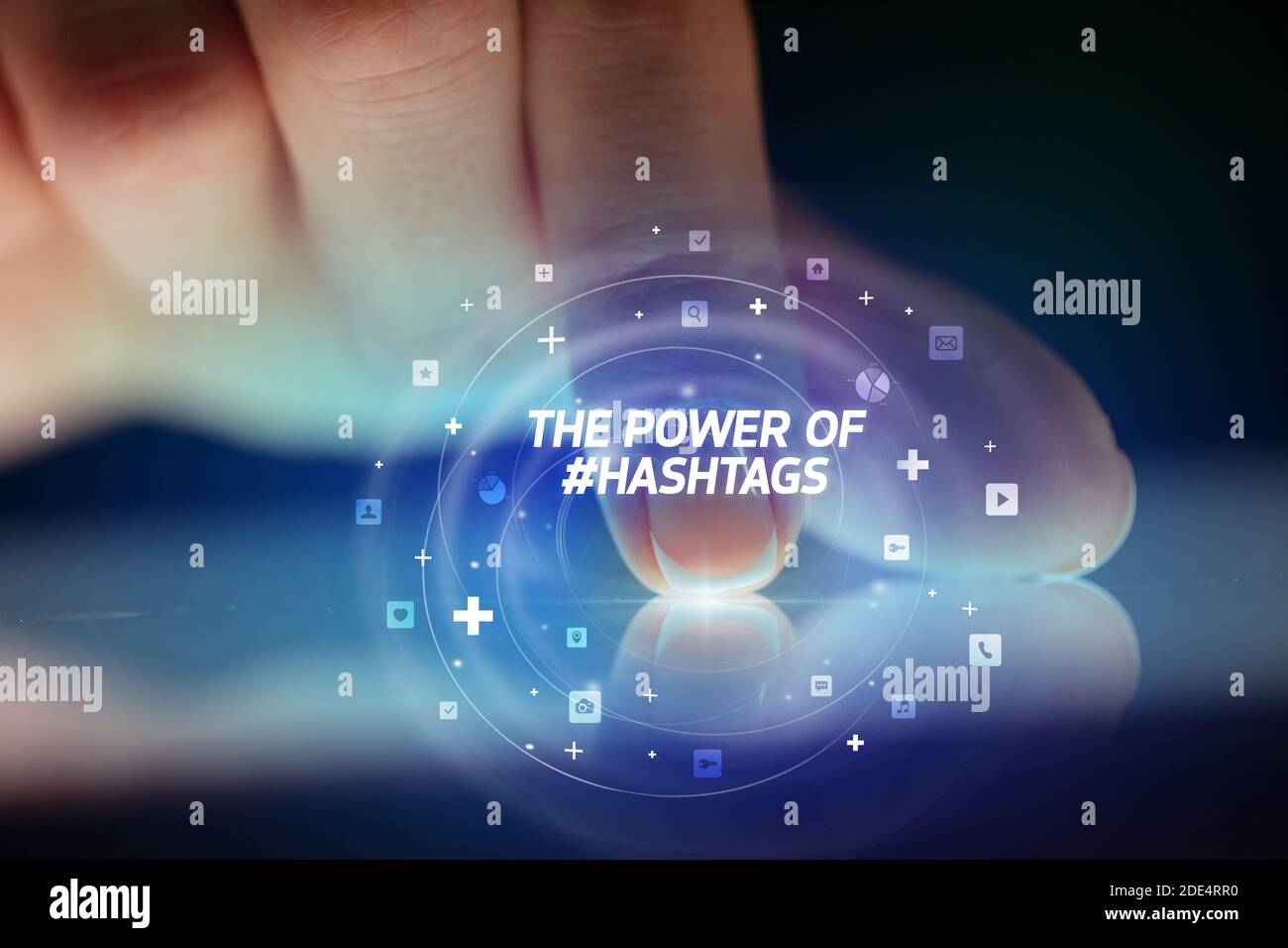 Finger touching tablet with social media icons and THE POWE OF # ...