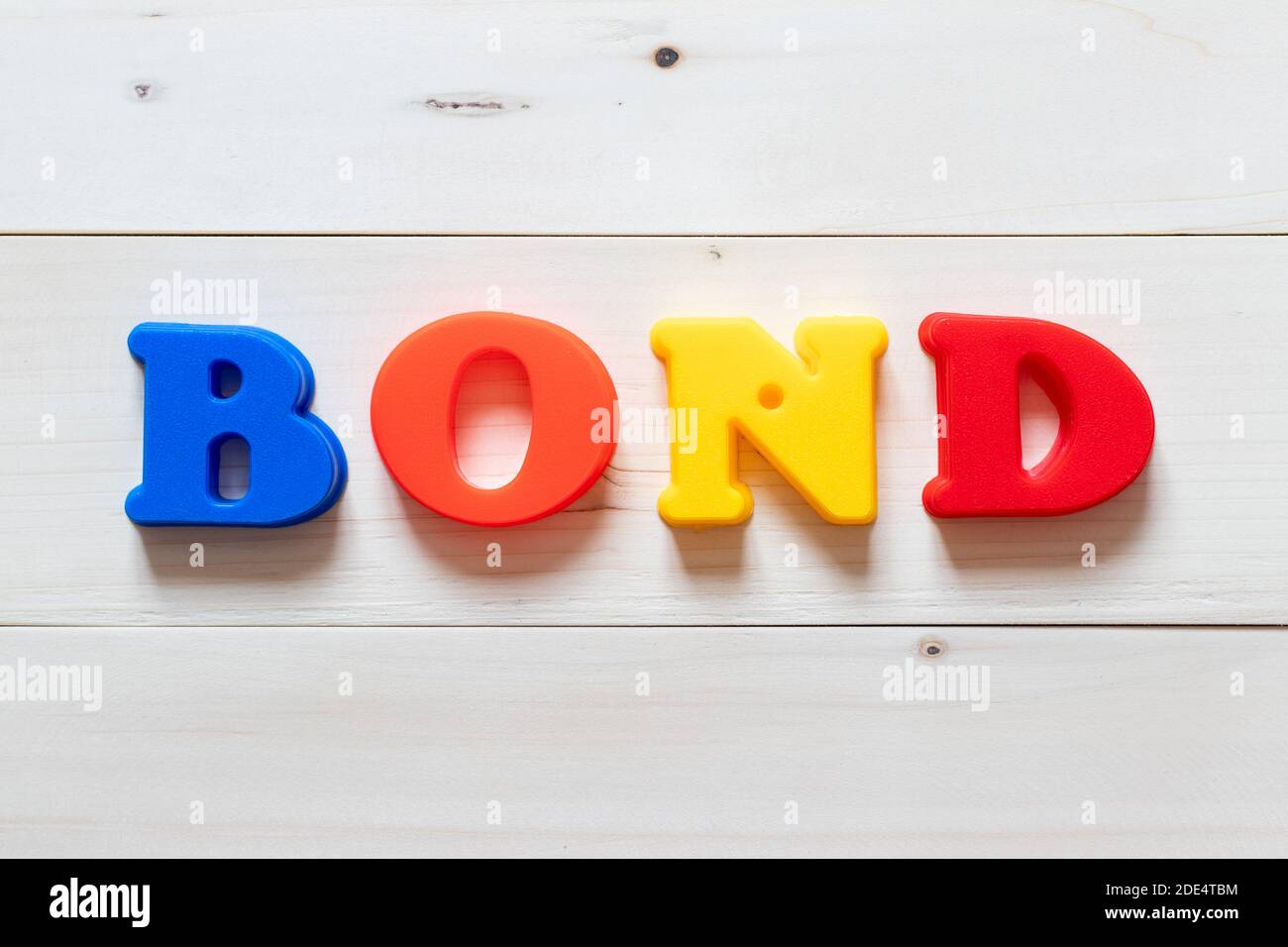 Letter block in word bond on white wood background Stock Photo - Alamy