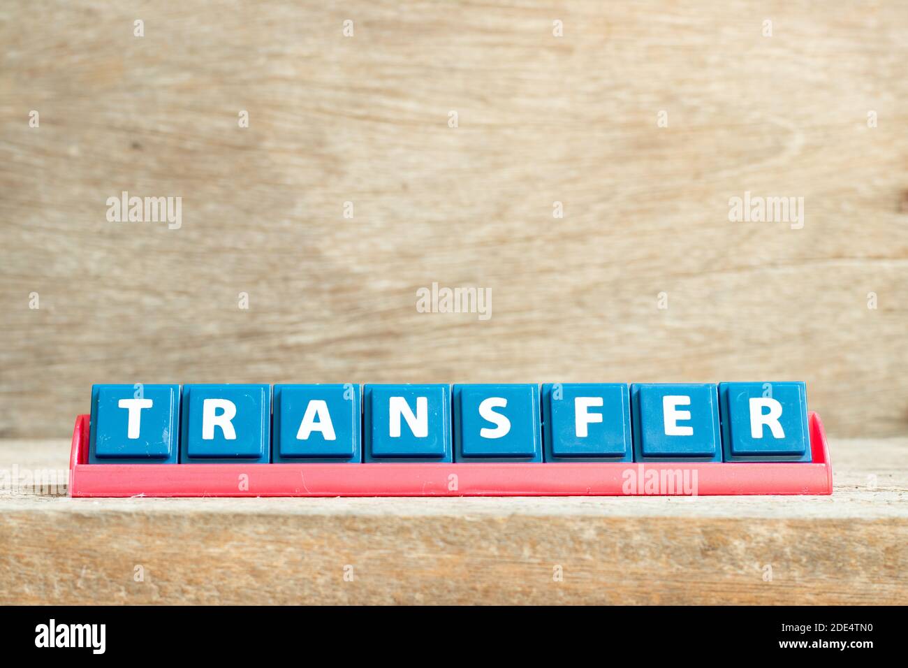 Tile letter on red rack in word transfer on wood background Stock Photo ...