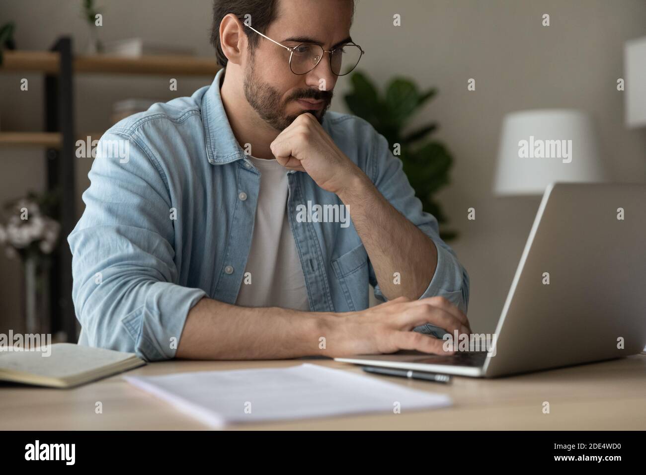 Focused man work look at laptop screen thinking Stock Photo - Alamy