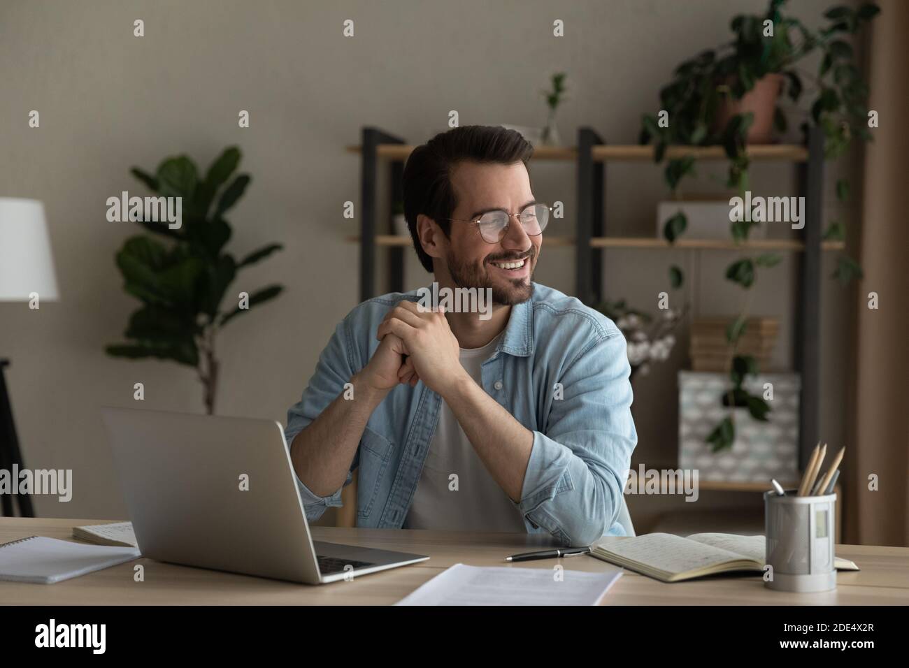 Smiling young man dream distracted from computer work Stock Photo - Alamy