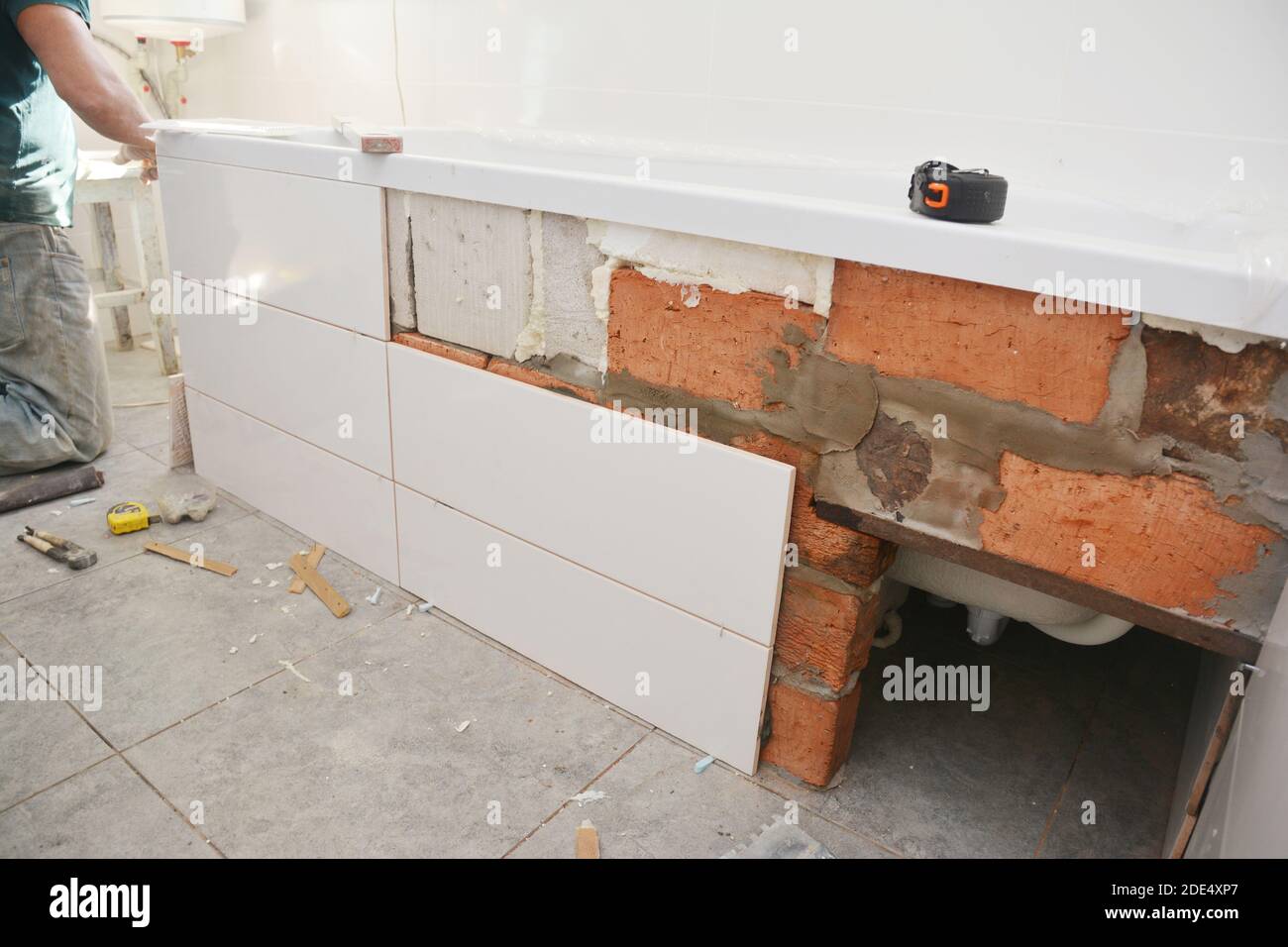 An unfinished bath tub installation with ceramic tiles in house ...