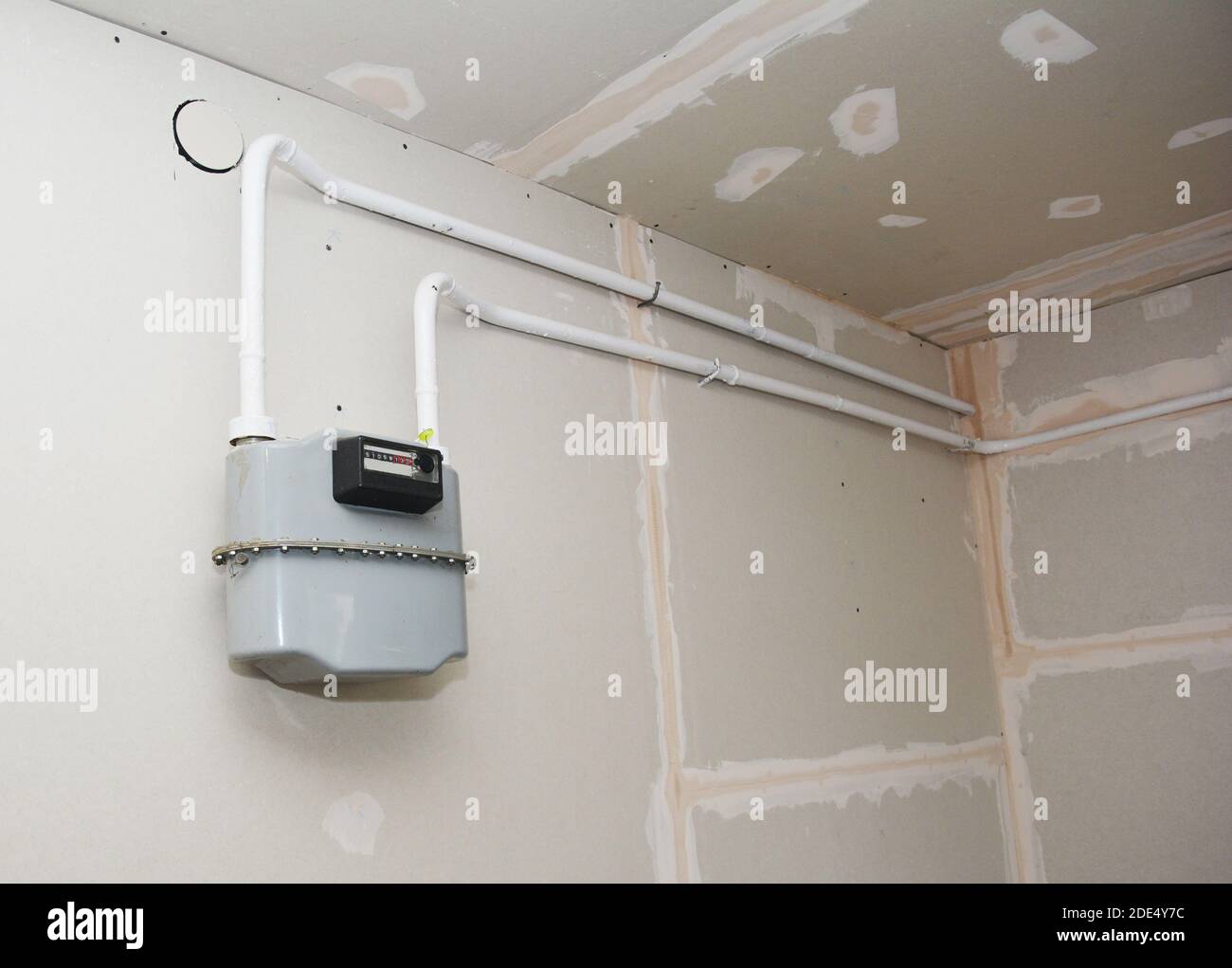Gas meter and natural gas pipeline in room with plasterboard, drywall ...