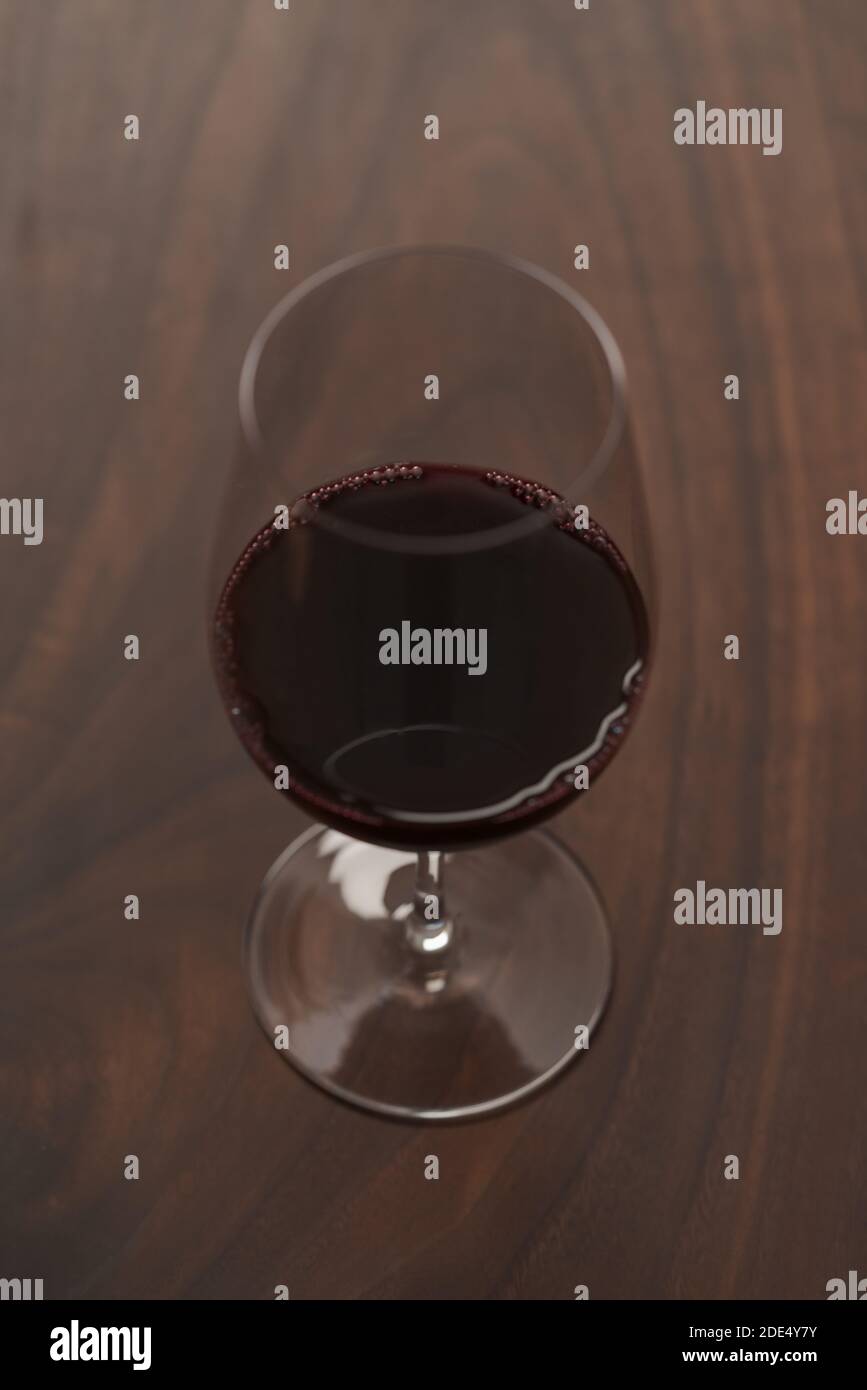Red wine in wineglass on black walnut table , shallow focus Stock Photo ...
