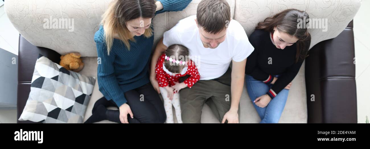 Parents with children sit on sofa in front laptop Stock Photo - Alamy