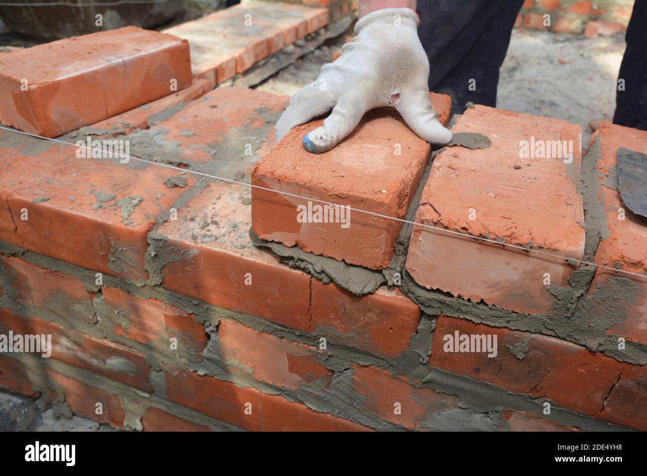 Bricklayers hands in masonry gloves bricklaying new house wall Stock ...