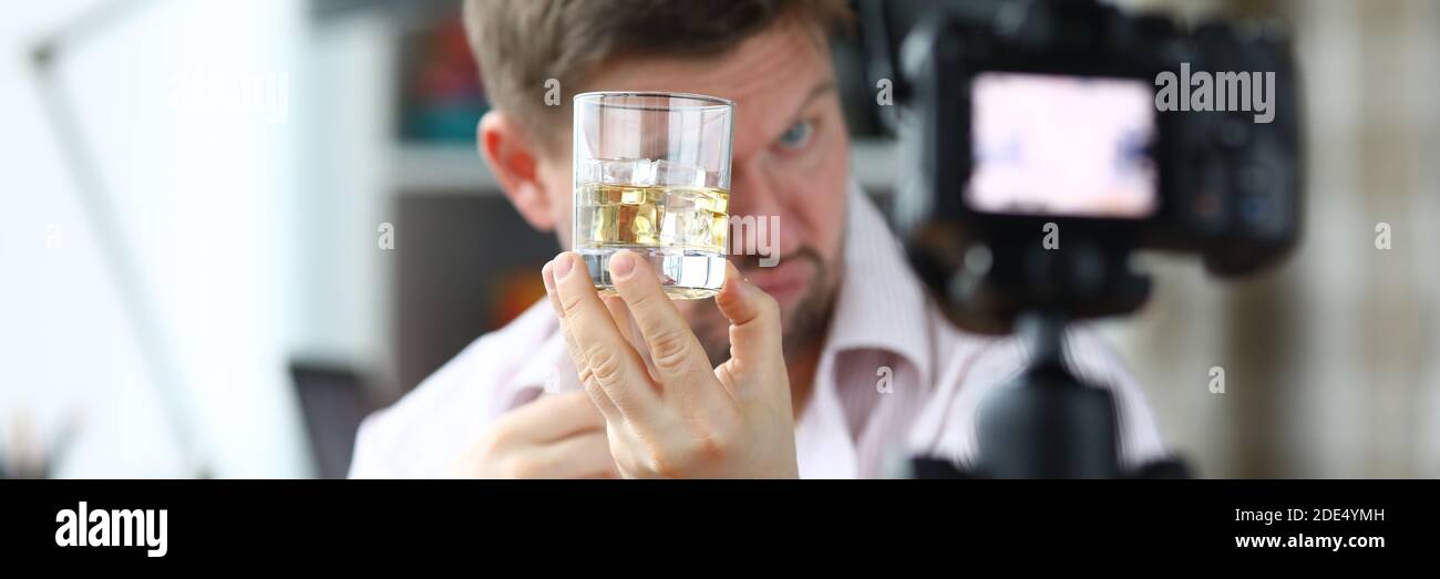 Drunk man looks glass alcohol and takes off camera Stock Photo - Alamy