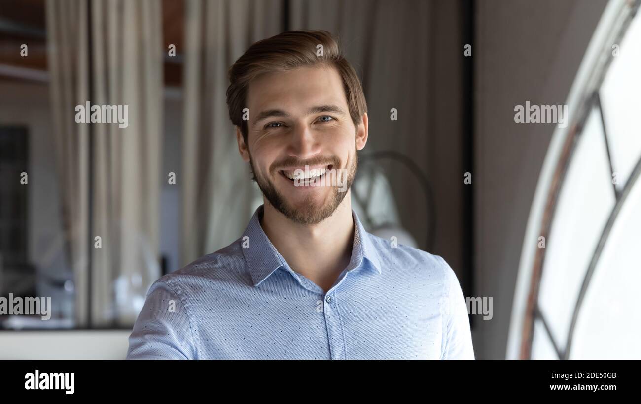 Happy friendly young man corporate employee smiling looking at camera ...