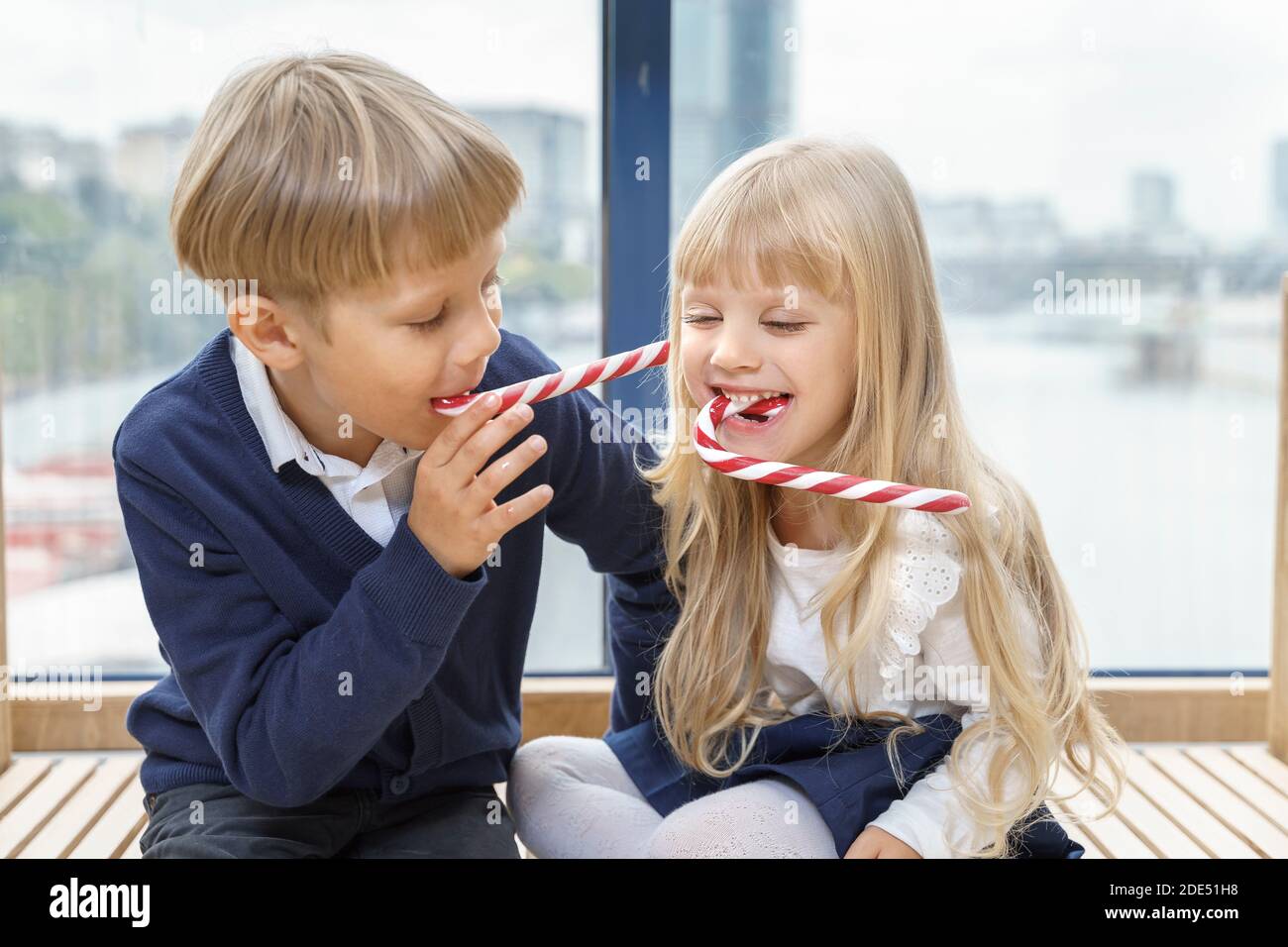 cute blondes boy and girl having fun with candy canes Stock Photo - Alamy