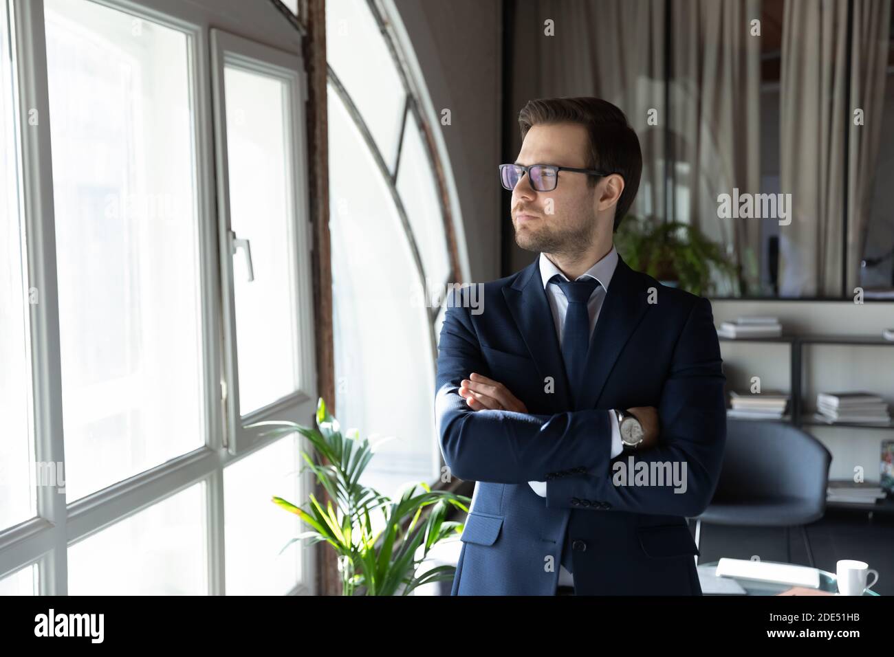 Businessman standing window looking distance hi-res stock photography ...