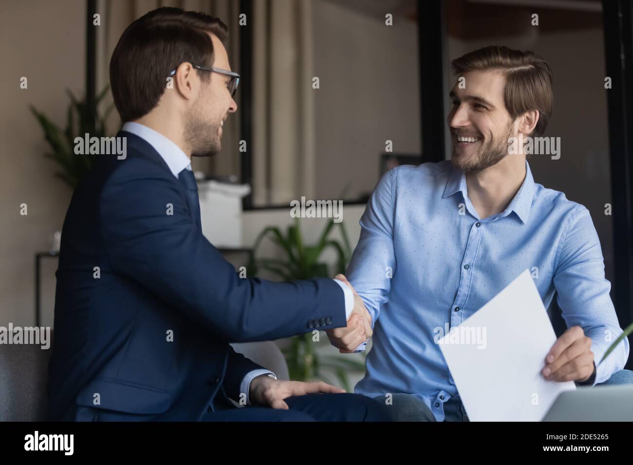 Client satisfied of getting loan insuring life handshaking with banker ...