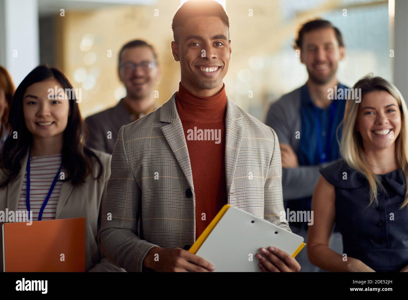 Group of cheerful job candidates waiting for an interview and posing ...