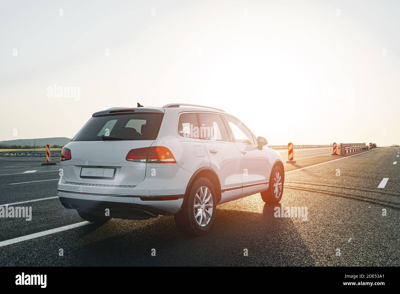 White crossover car on empty asphalt road at sunrise Stock Photo - Alamy