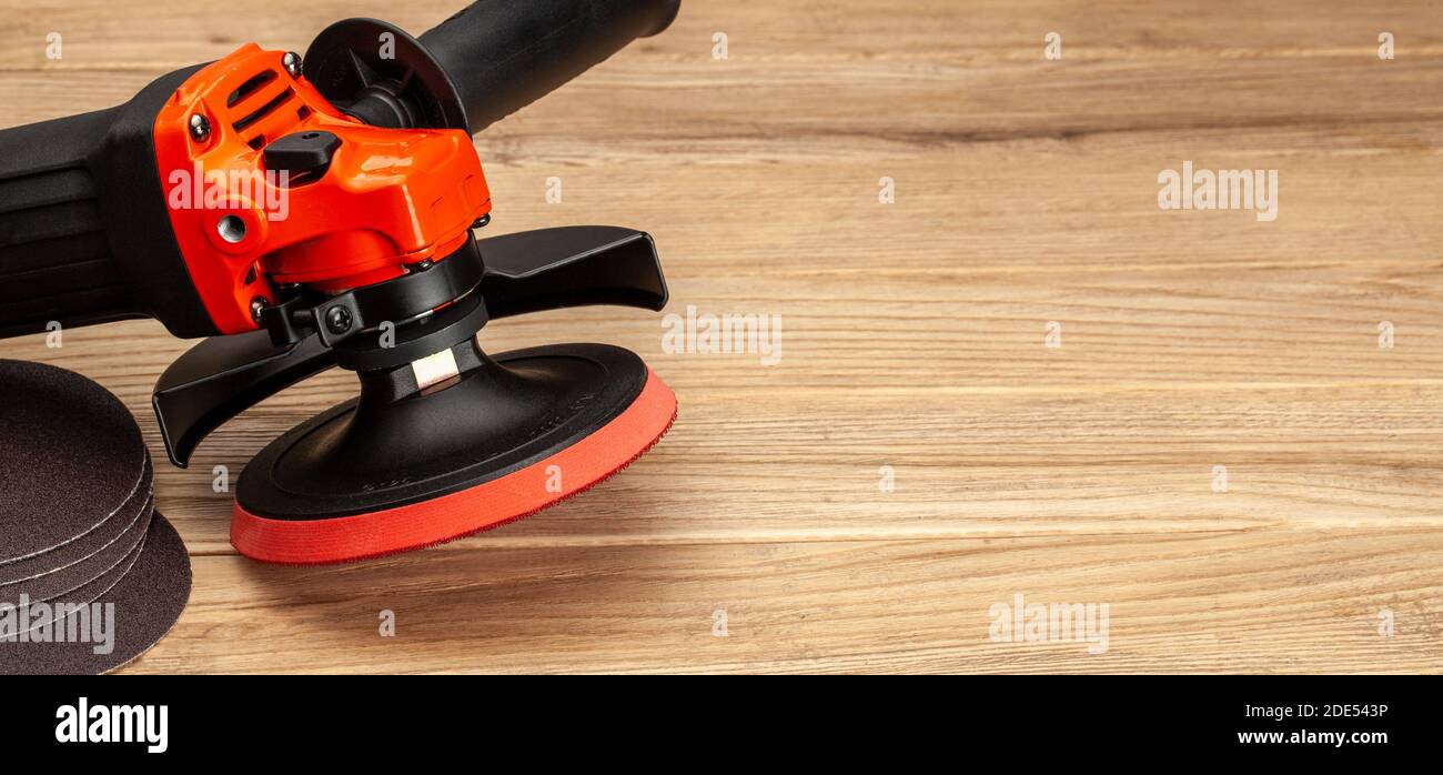 Angle grinder with sandpaper on wooden table. Copy space for text Stock ...