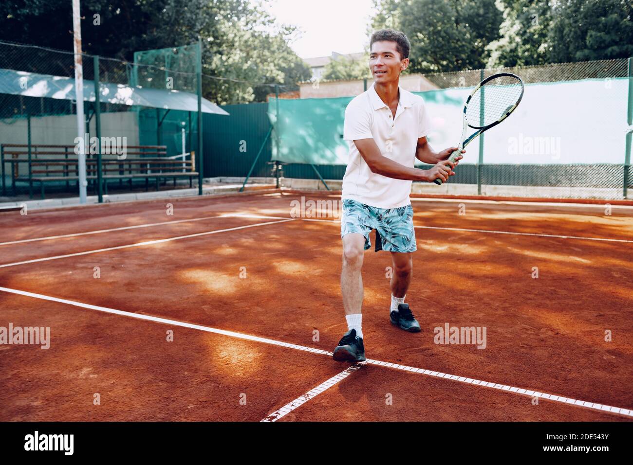 Fit man plays tennis on tennis field Stock Photo - Alamy