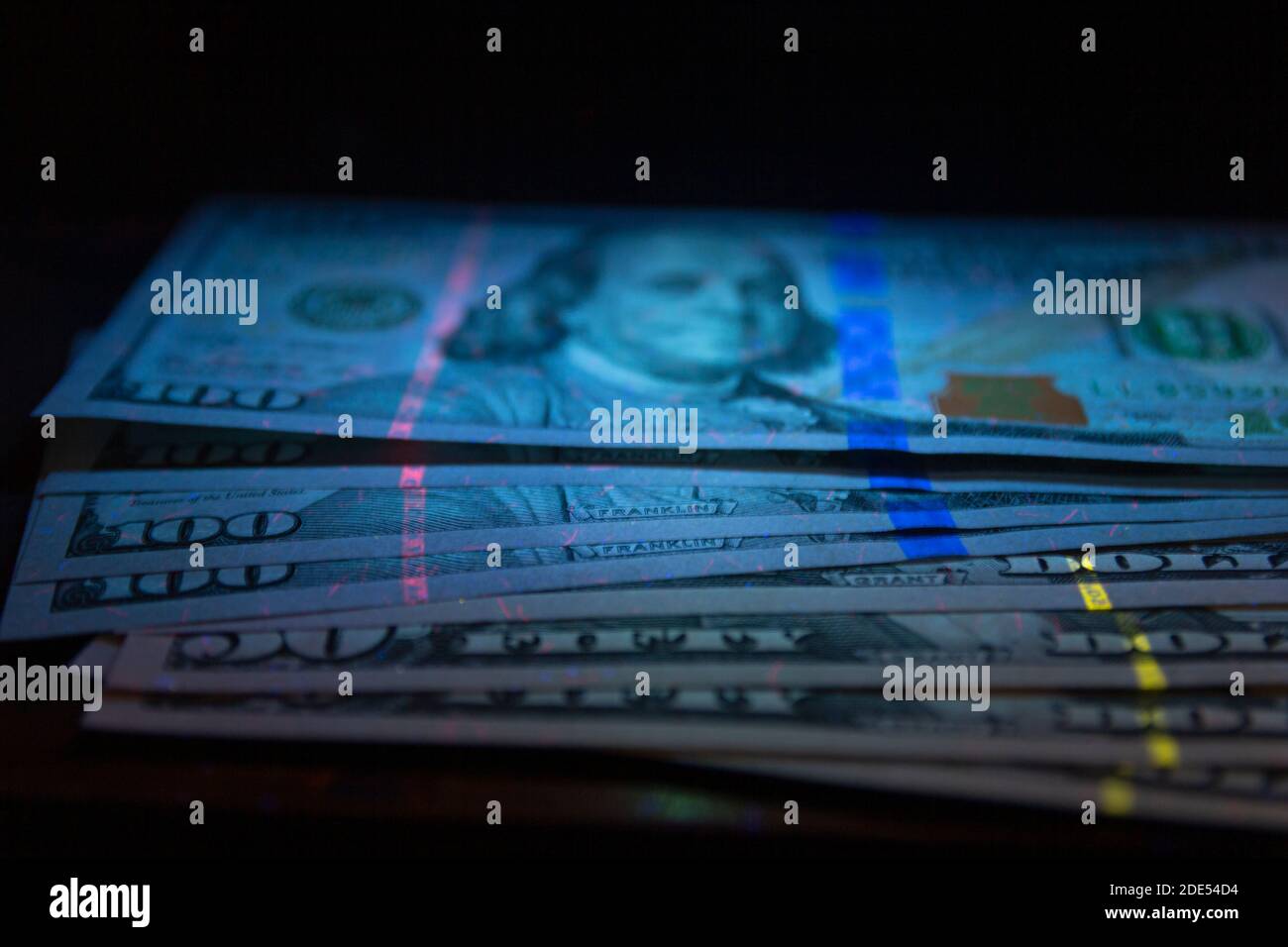 100 dollars banknot currency in UV light protection.Dollars in UV light ...