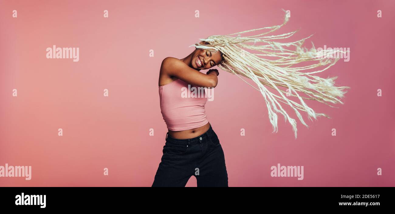 Portrait of happy woman dancing on pink background. Woman flying her ...
