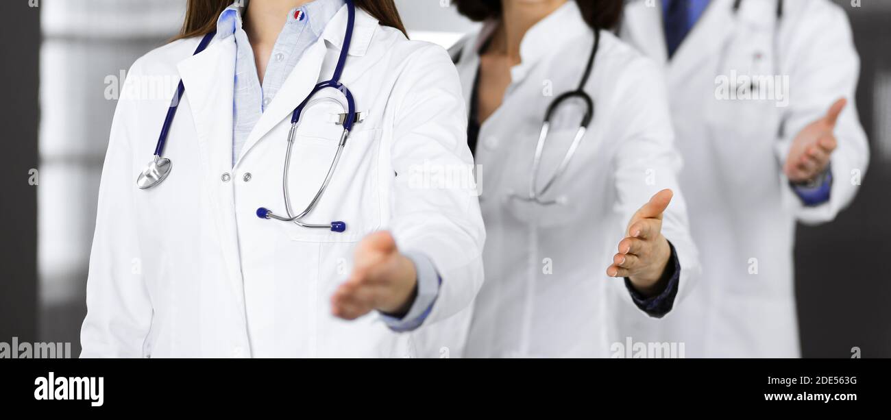 Group of doctors are standing as a team while offering their helping ...