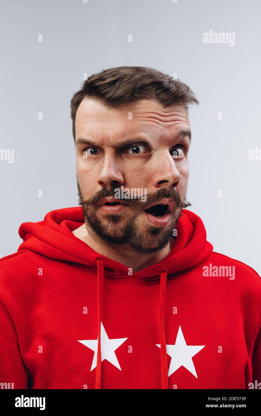 Calm and crazy. Young man with dual emotions combination on face ...