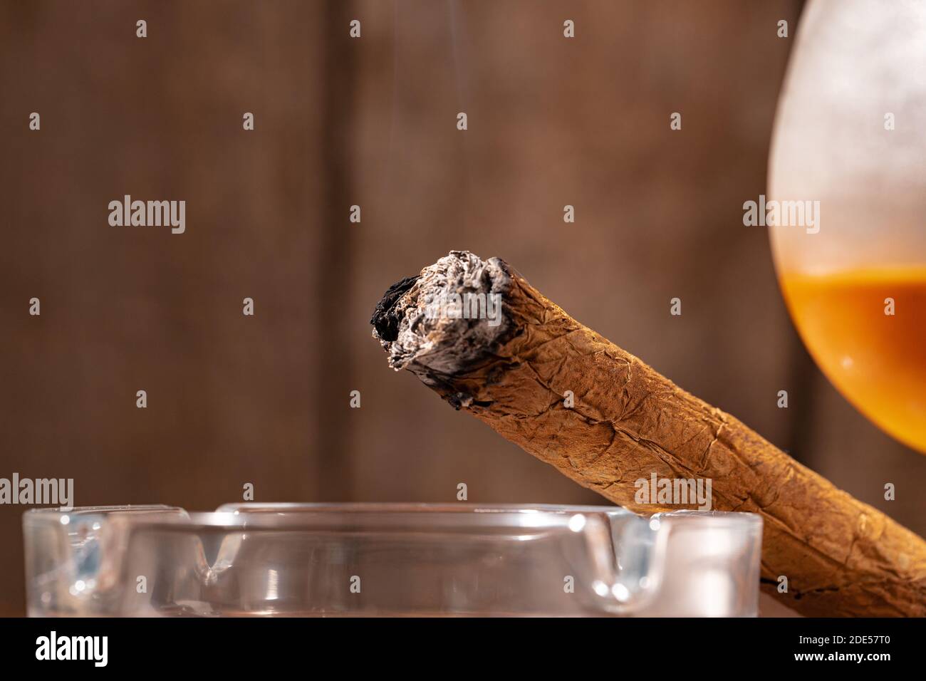 Glass of whisky and lighted cigar in an ash tray Stock Photo - Alamy