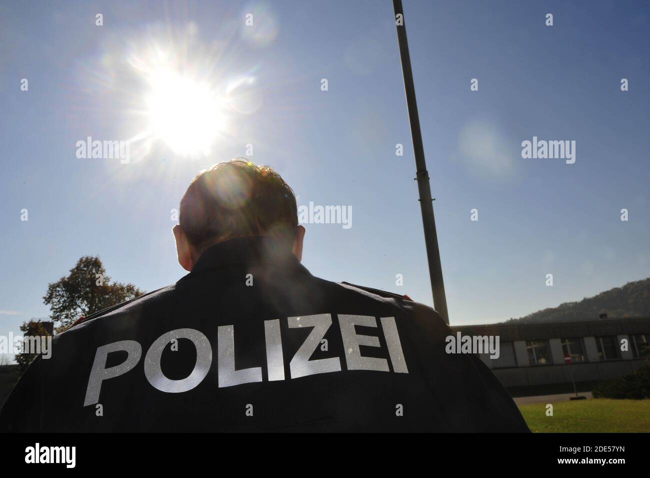 Polizei (police) officer in uniform in an residential area, sun shining ...
