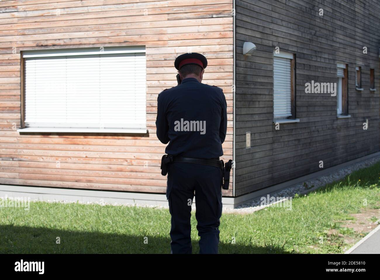 Polizei (police) officer in uniform with weapon, on the phone, in front ...