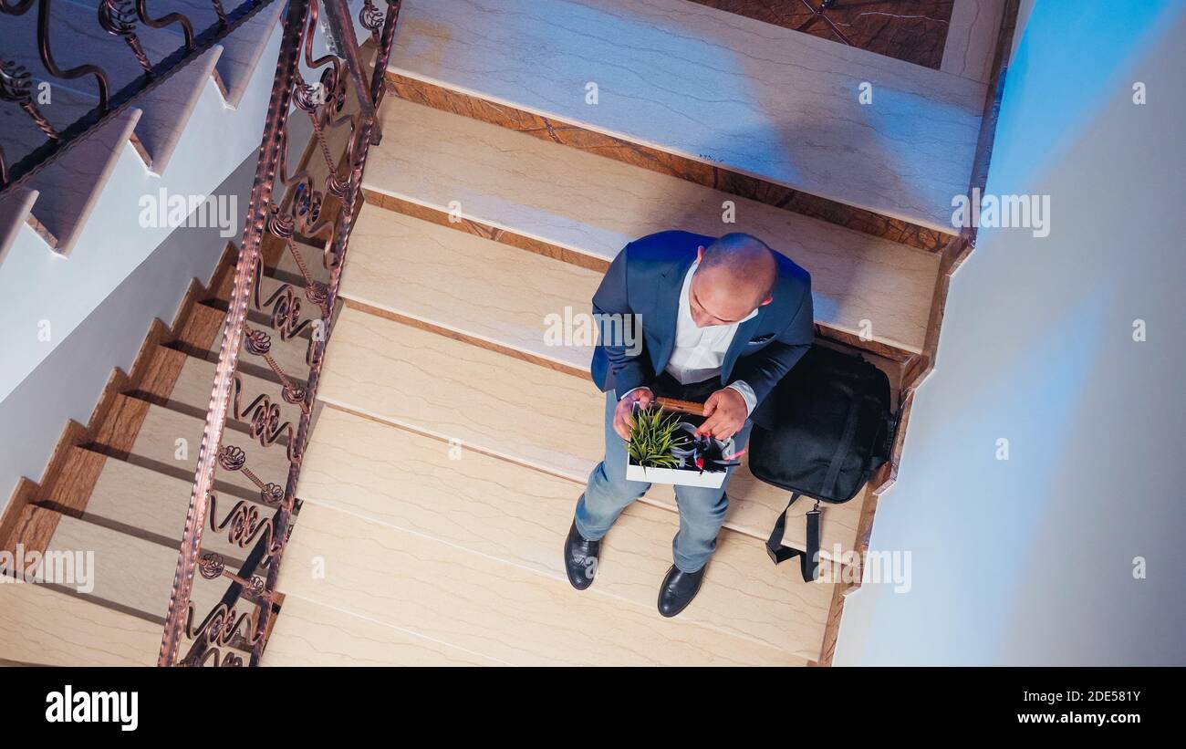 Top view of upset businessman getting fired sitting on office staircase ...