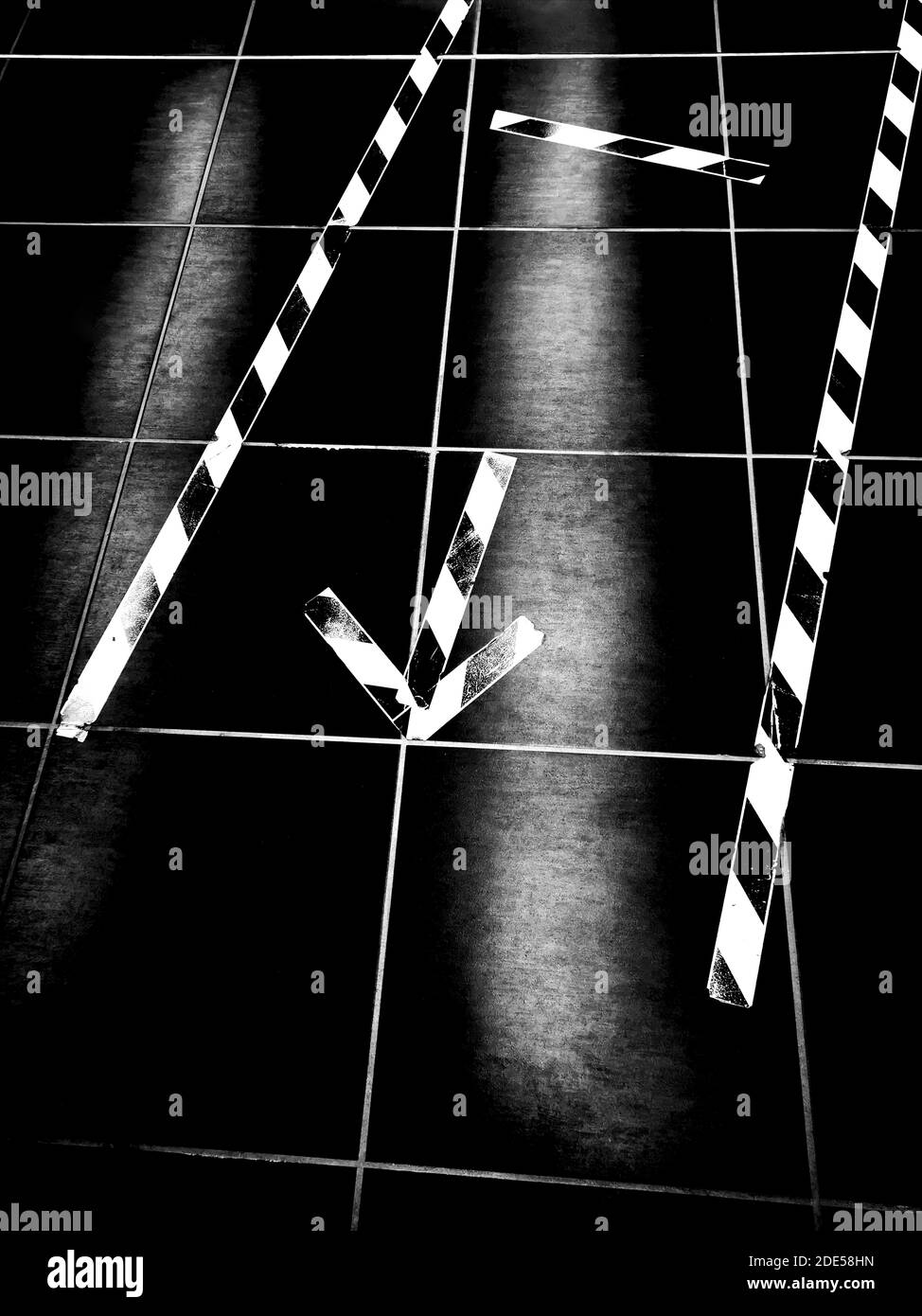 A vertical grayscale of a black tiled floor with an arrow on it Stock ...