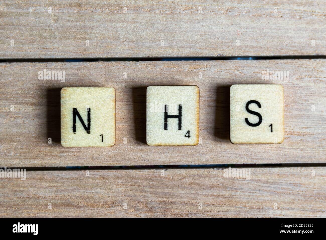 Old worn vintage wooden textured cubes with letters spelling NHS ...