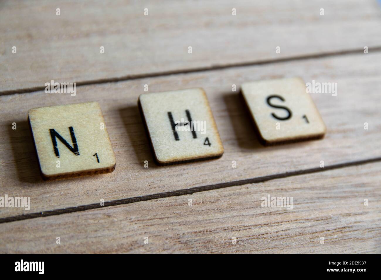 Old worn vintage wooden textured cubes with letters spelling NHS ...