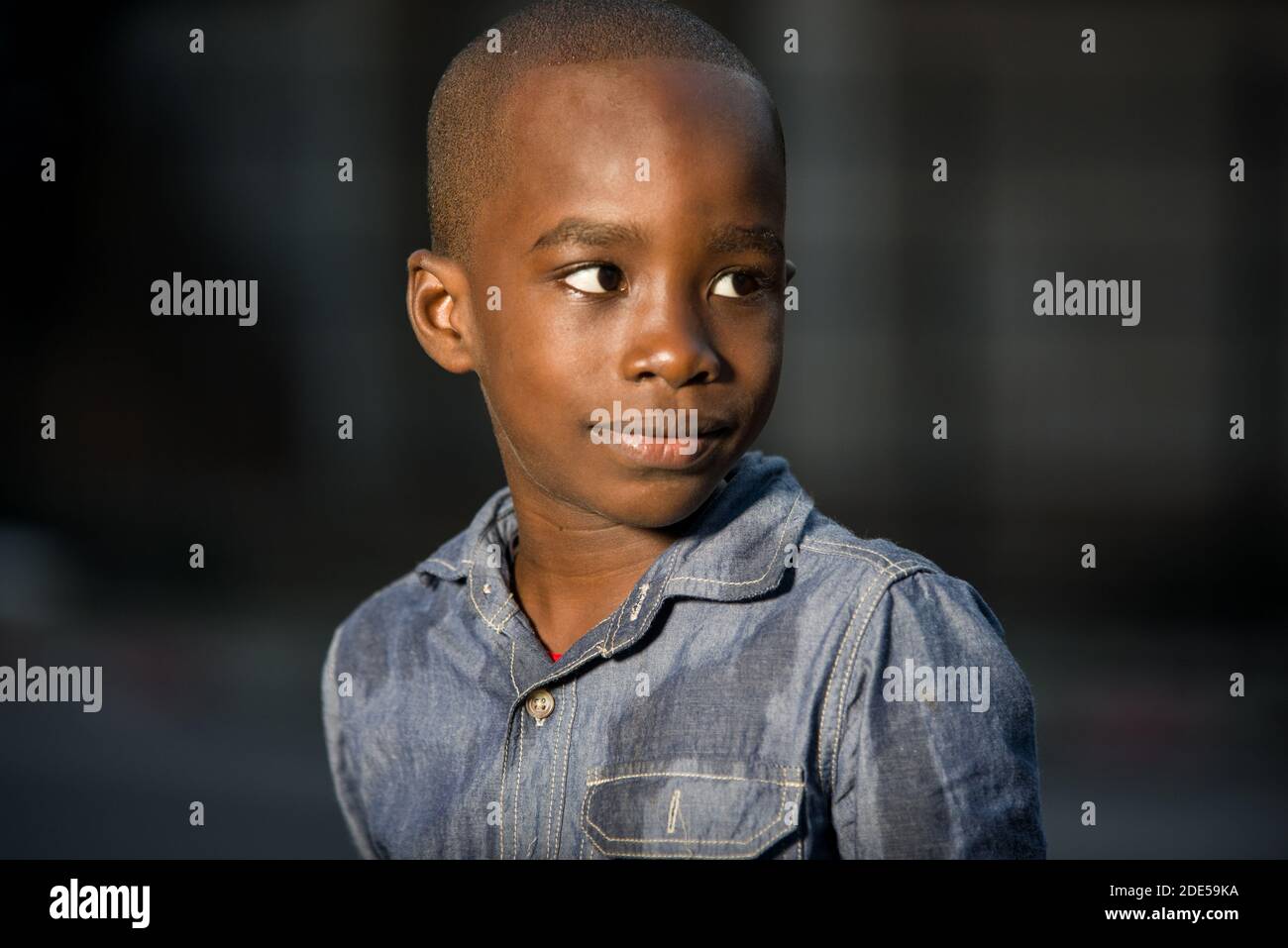 Close-up of a young boy with a smile on his face and looking at his ...